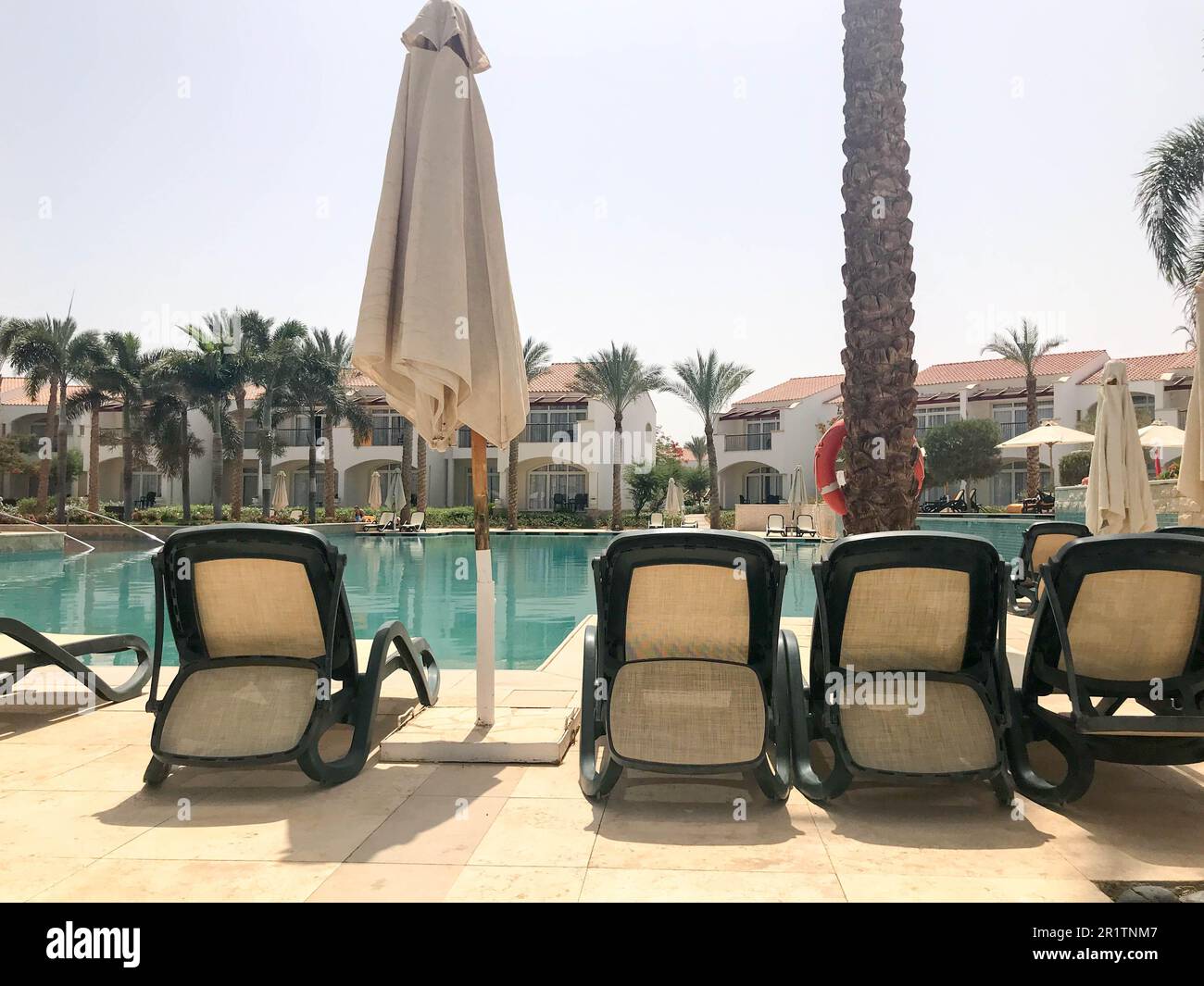 Relax pool with clear blue water with sunbeds for sunbathing with sun ...