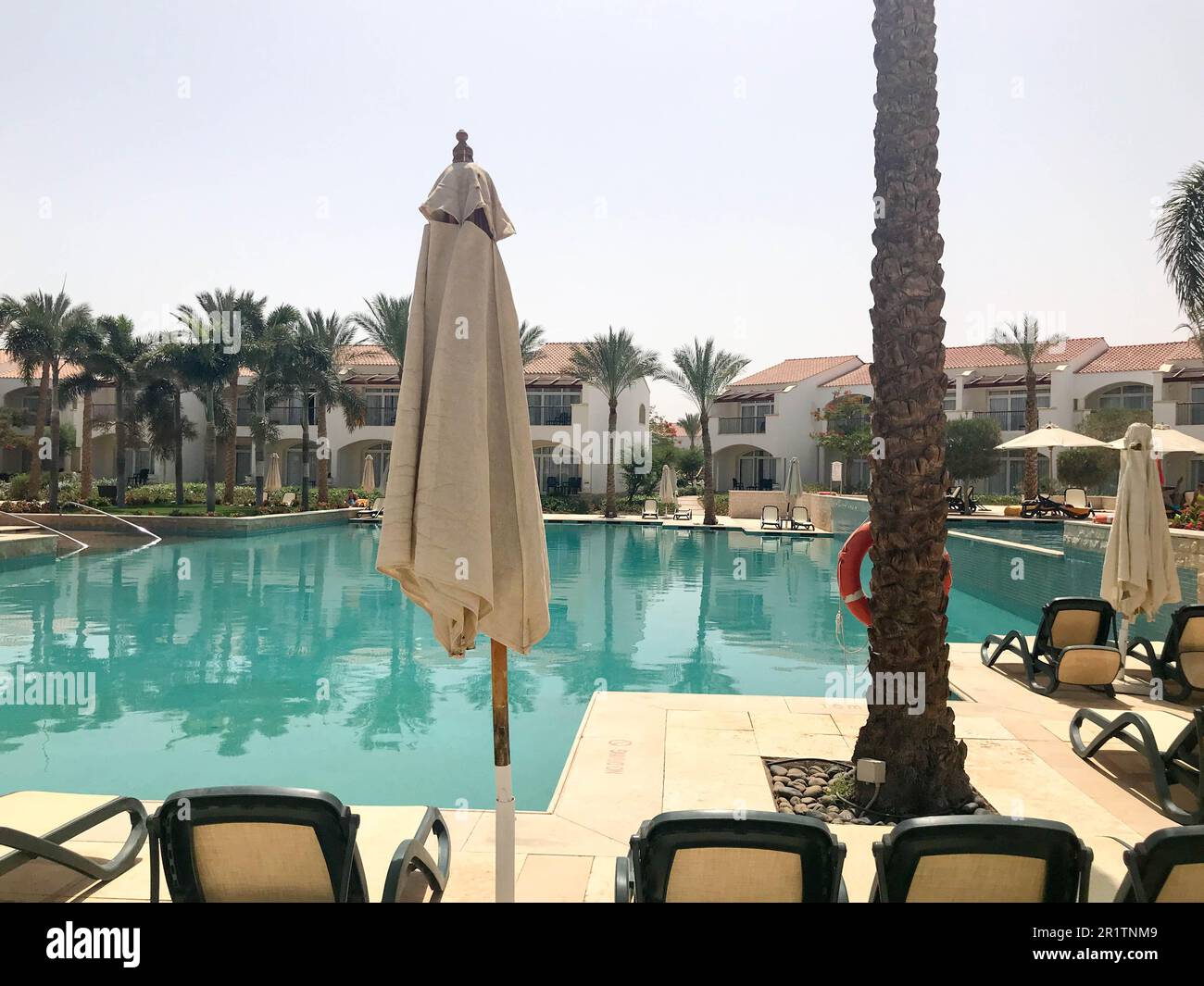 Relax pool with clear blue water with sunbeds for sunbathing with sun ...