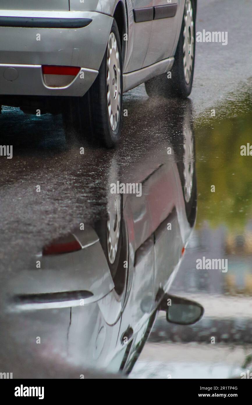 The Side of the car reflecting on the water on the road Stock Photo - Alamy