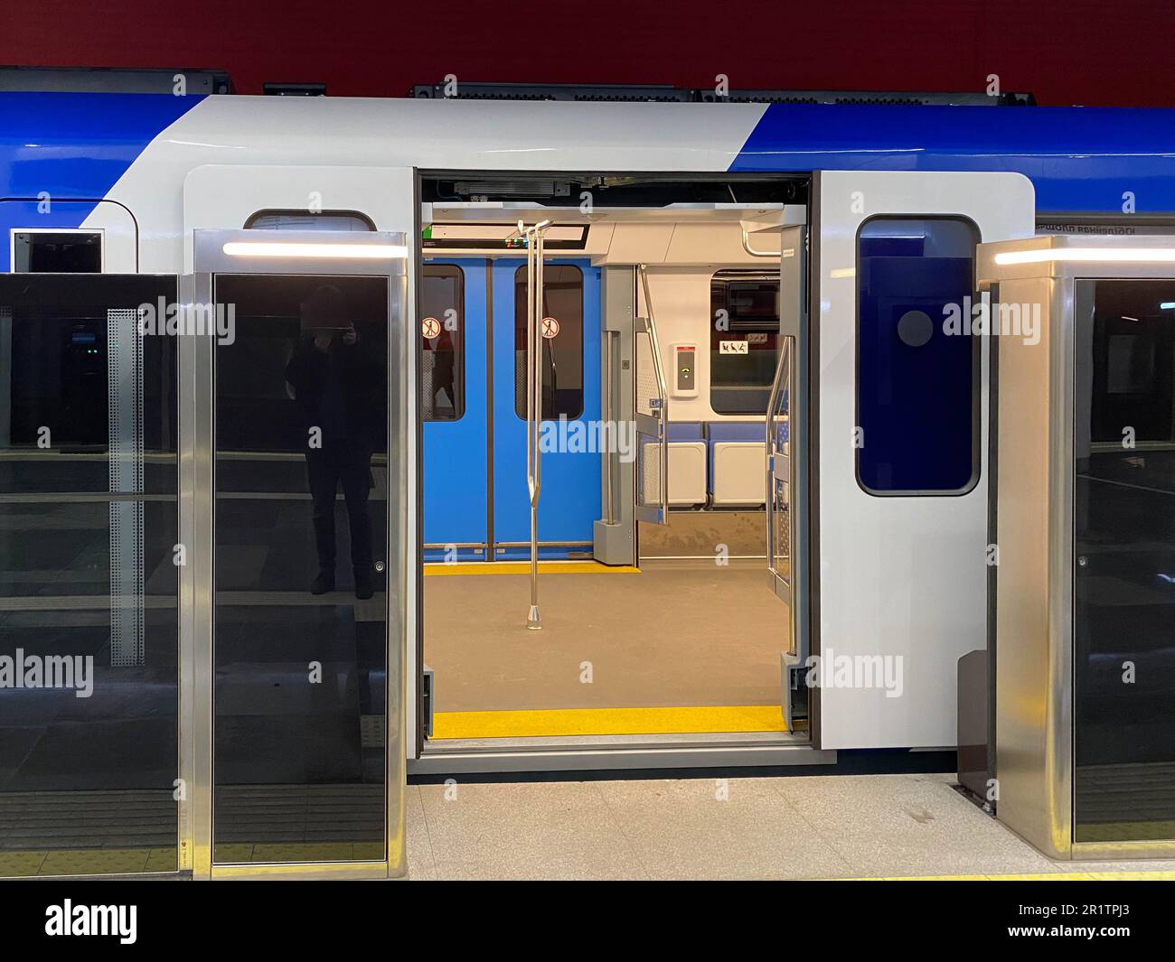 A blue electric train carriage with an open sliding mechanical door at ...