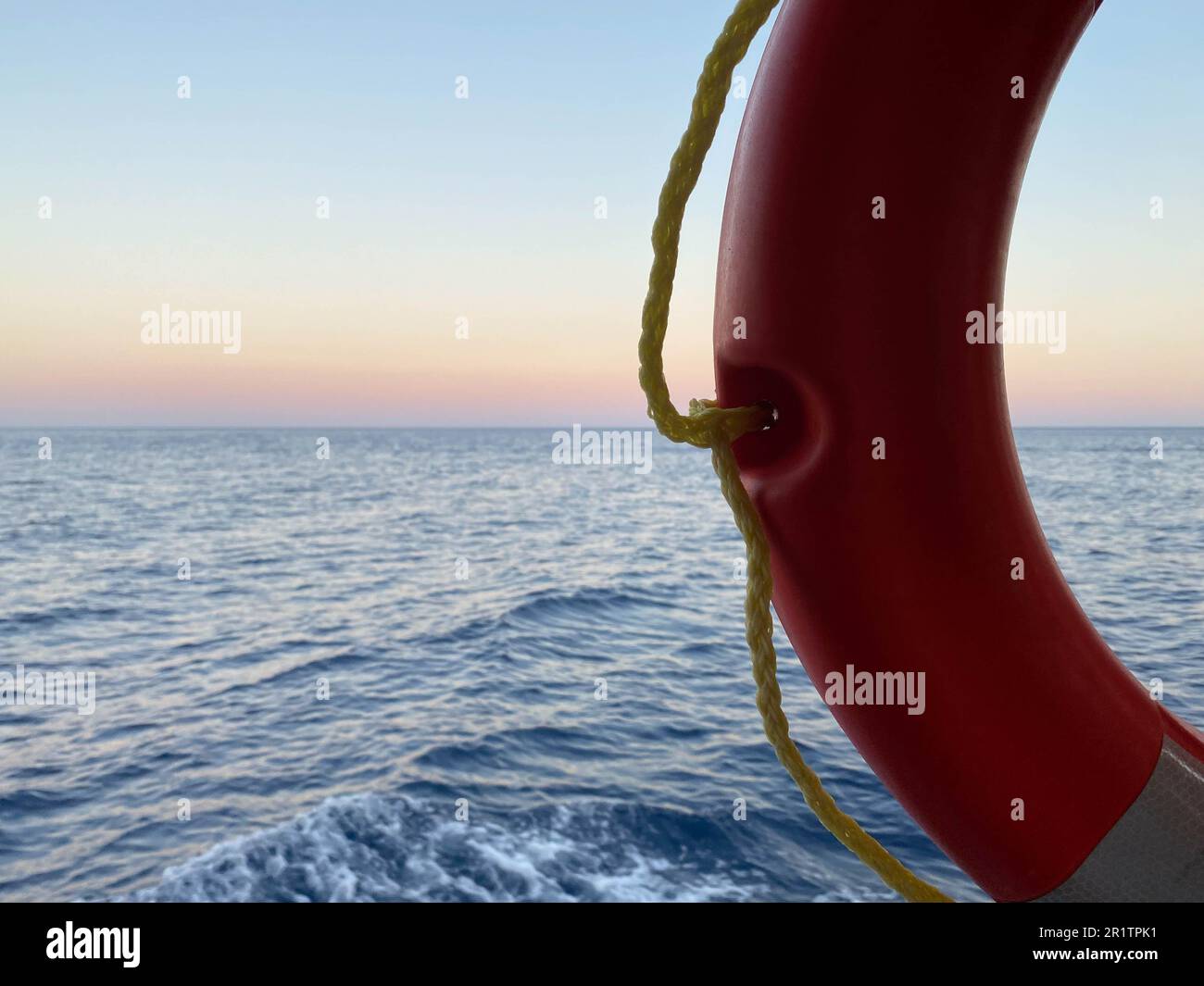 Red lifebuoy on ship railing with sea surface Stock Photo - Alamy
