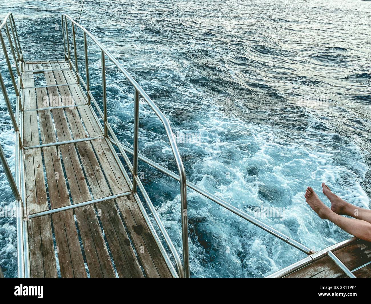 bridge made of wood with metal breaks into the sea. water with waves ...