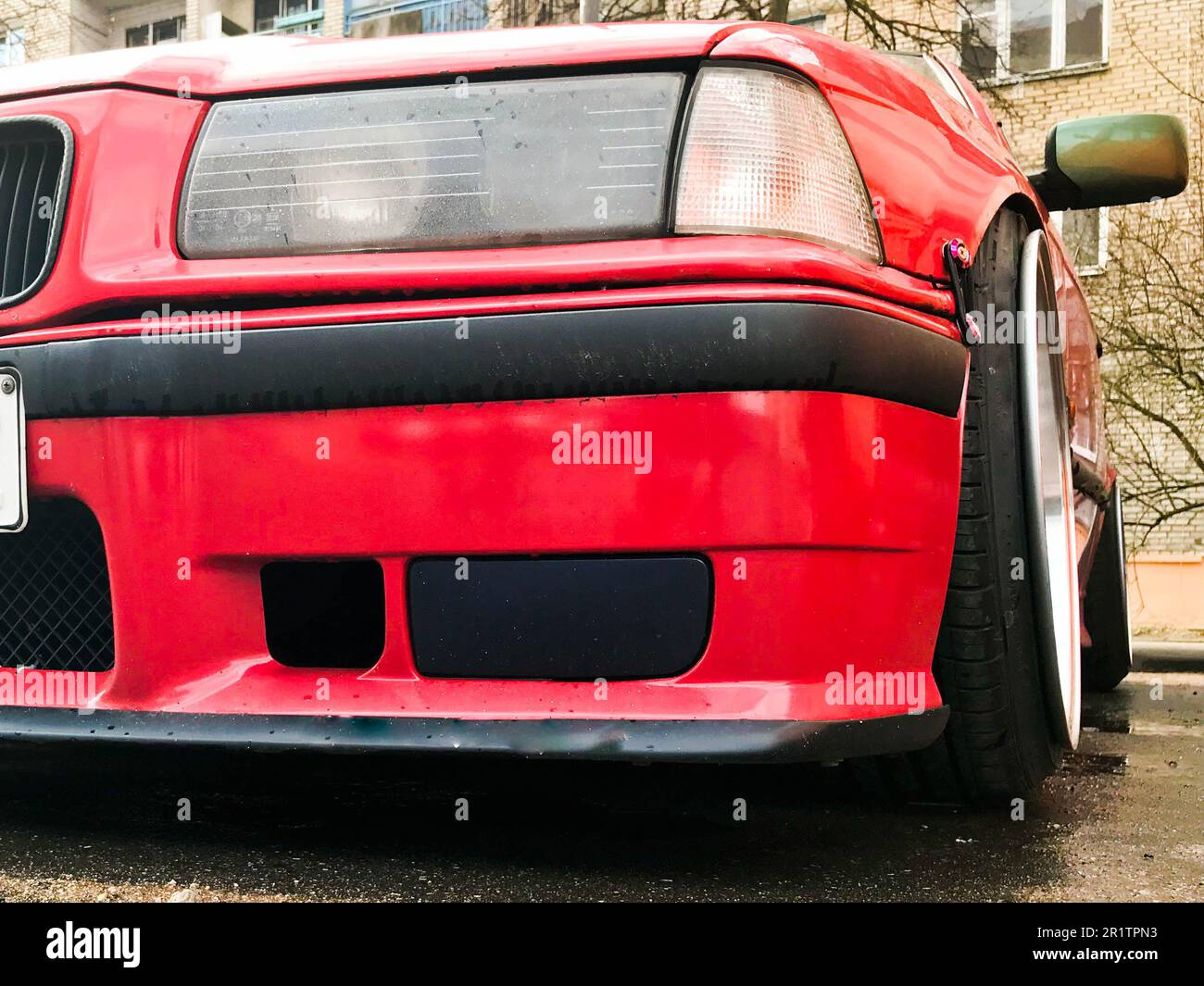 Beautiful big racing wheels of a sports red car with a very low ground ...