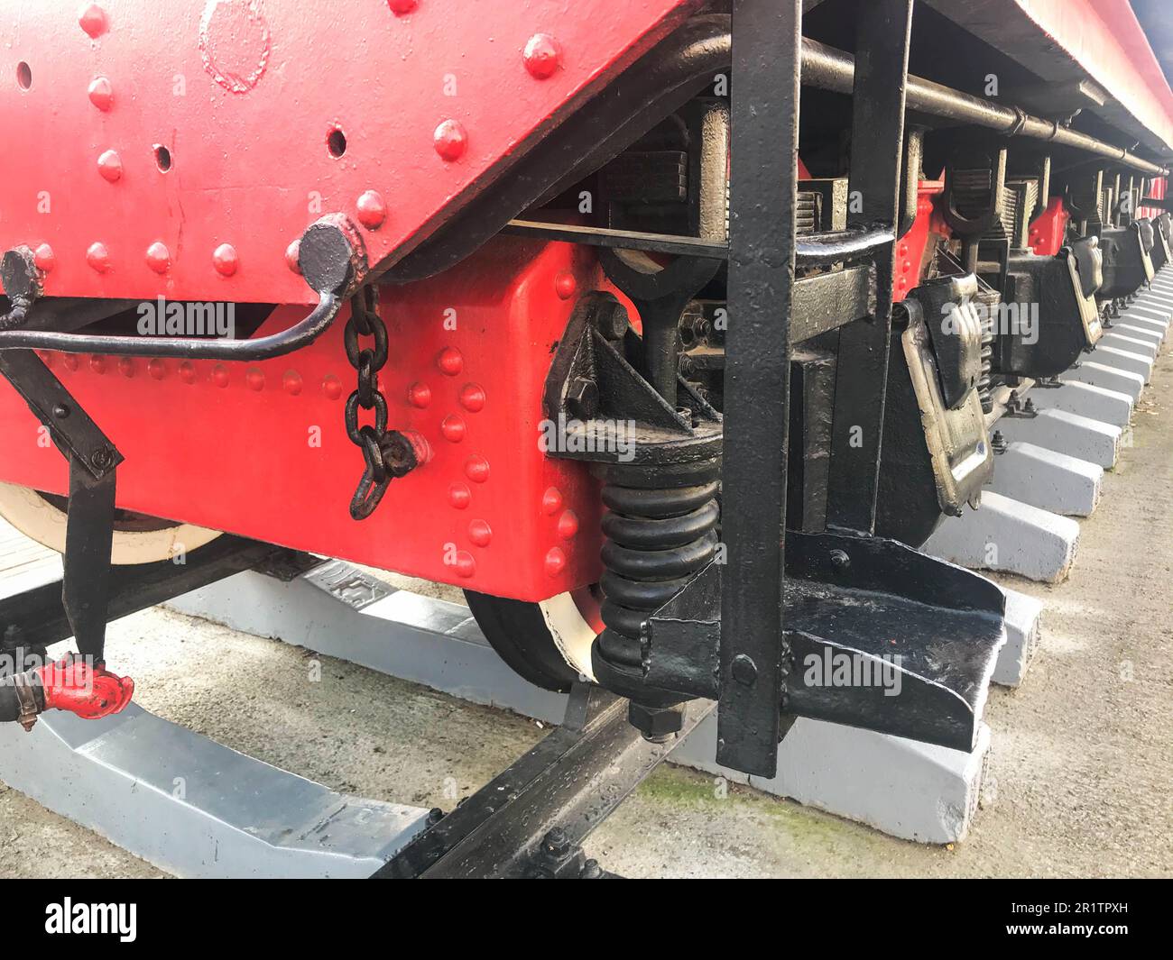 Large iron wheels of a red and black train standing on rails and ...