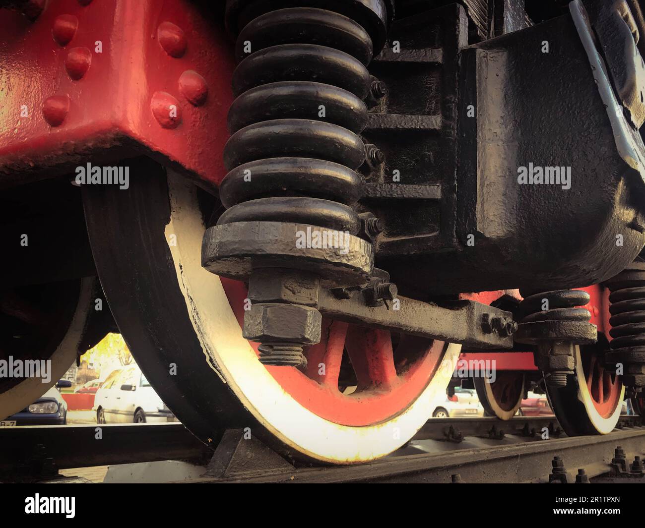 Large iron wheels of a red and black train standing on rails and ...
