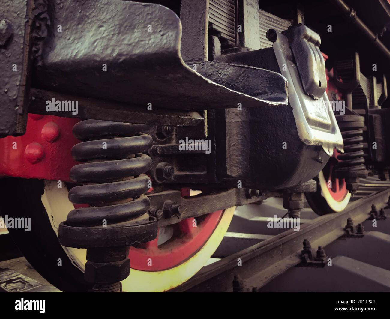 Large iron wheels of a red and black train standing on rails and ...