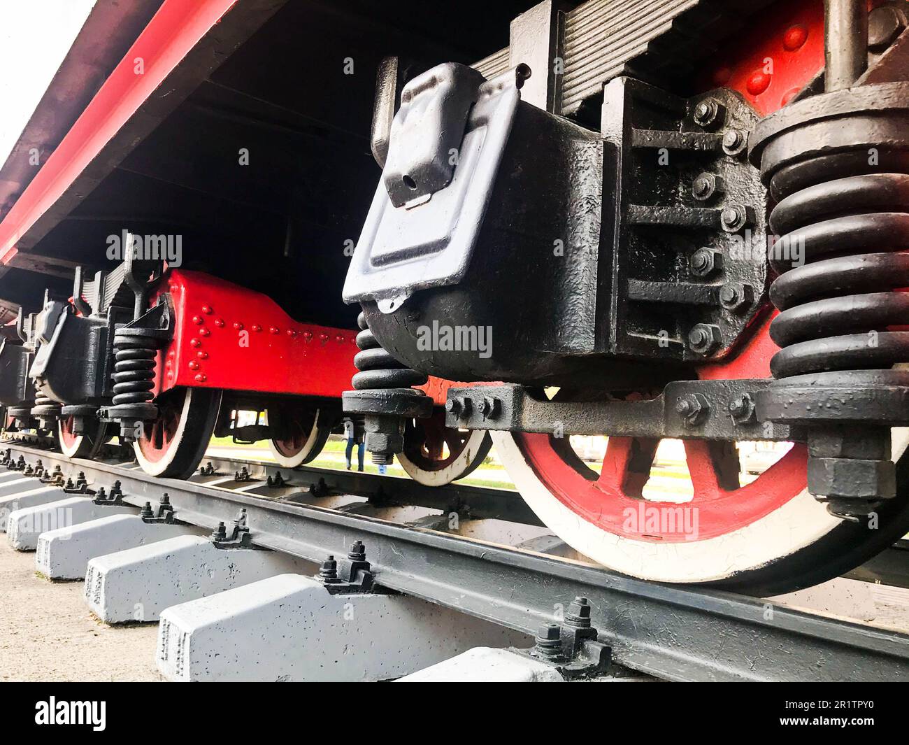 Large iron wheels of a red and black train standing on rails and ...