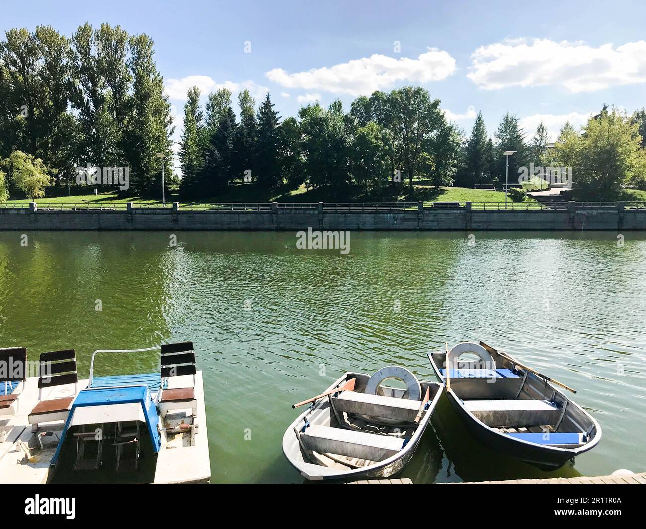 Boats and catamarans on a pond lake in a river canal with green ...