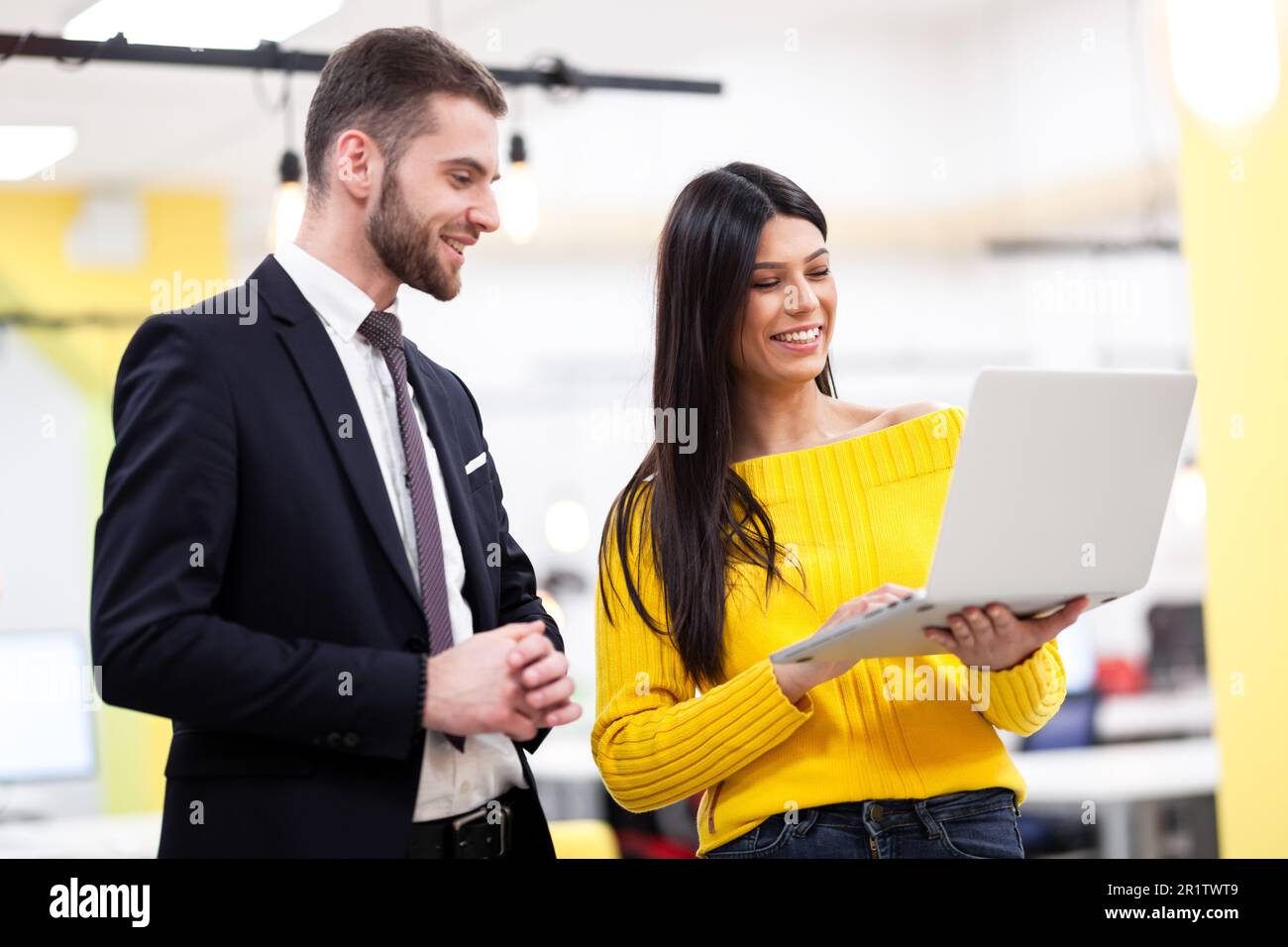 Beautiful Caucasian dark haired girl in yellow posing with businessman ...