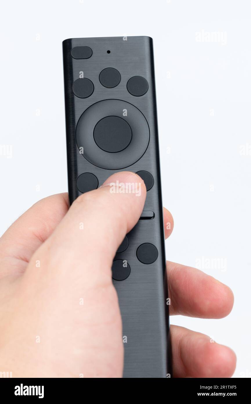 Black modern tv remote control in hand isolated on white studio ...
