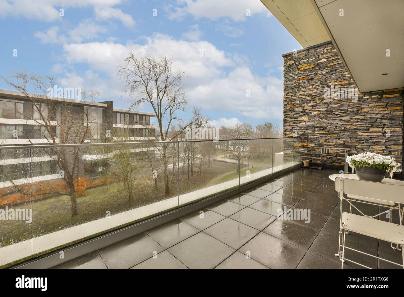 an outside area with some tables and chairs on the balcony looking out ...