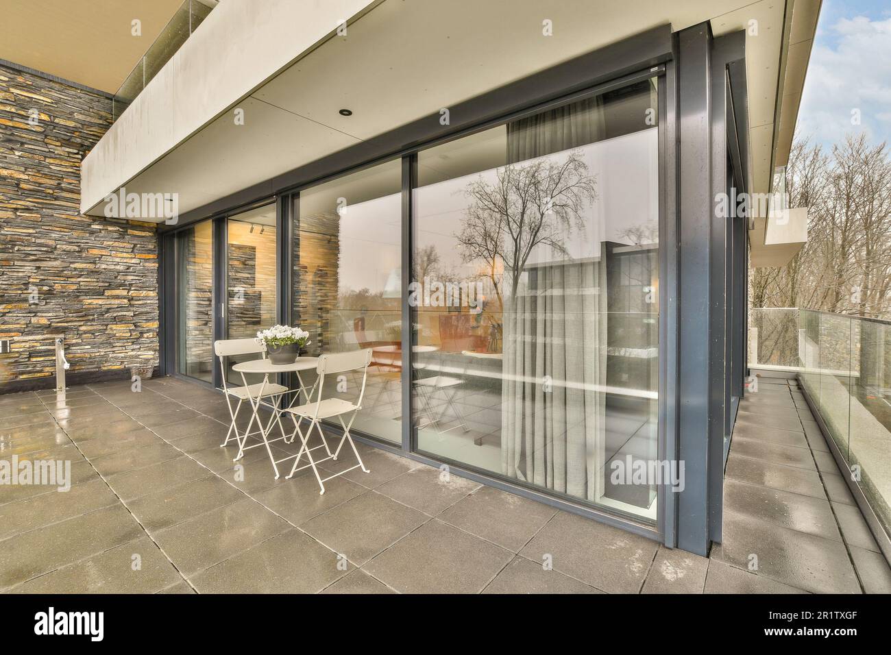 a patio with chairs and tables on the outside, looking out to the trees ...