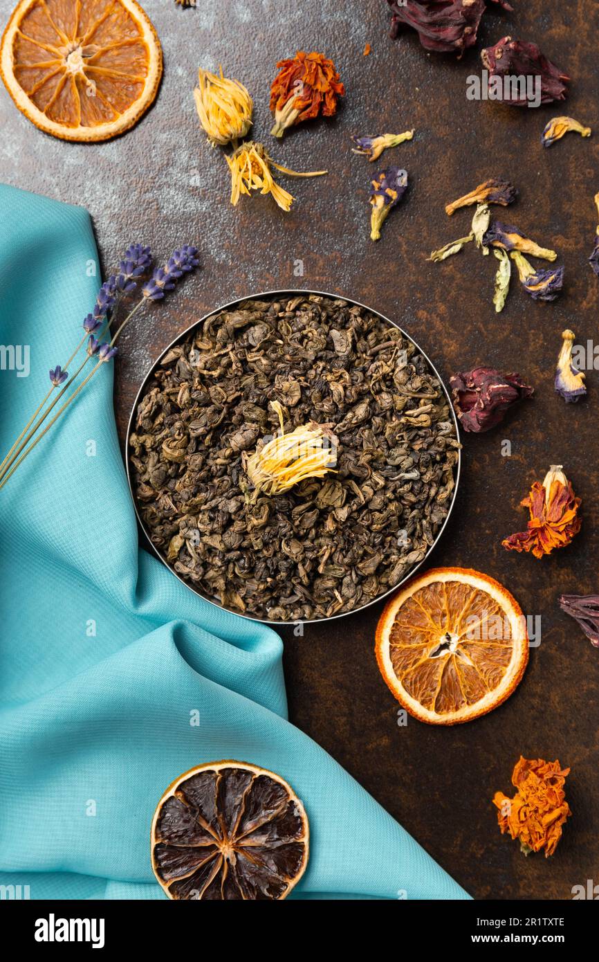 Composition of green, flower tea and dried orange slices on blue and ...