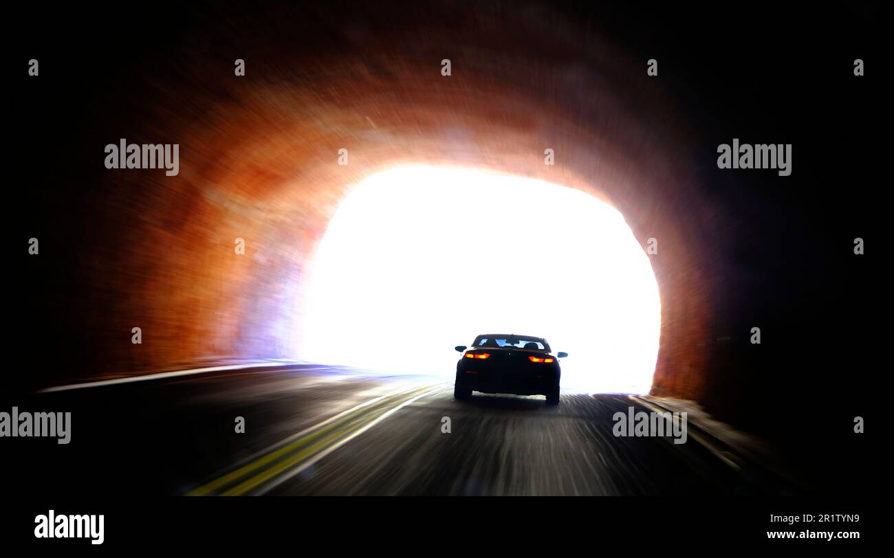 Car driving through dark tunnel and entering light of freedom speed ...