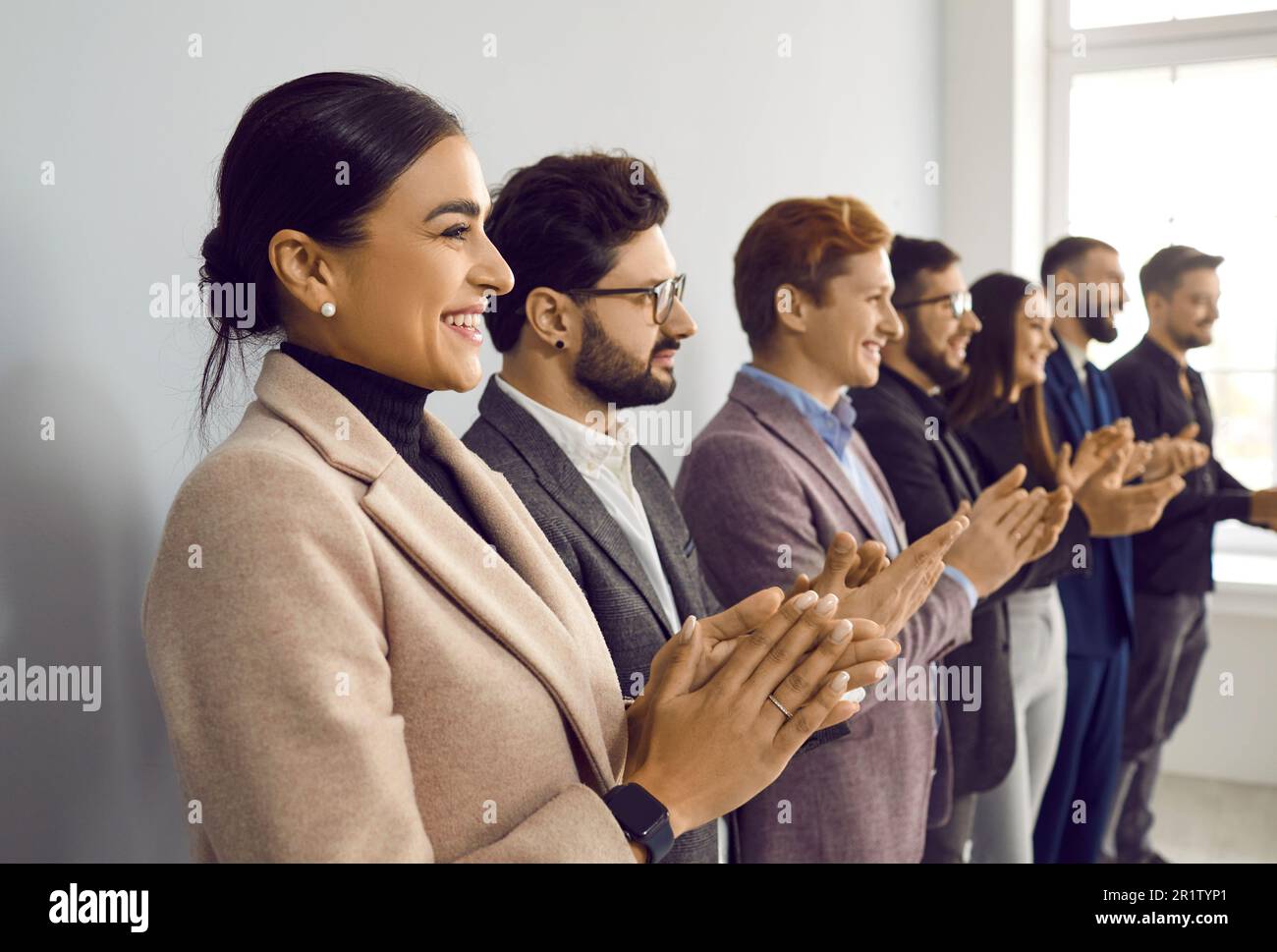 Happy smiling professional young business people clap their hands ...