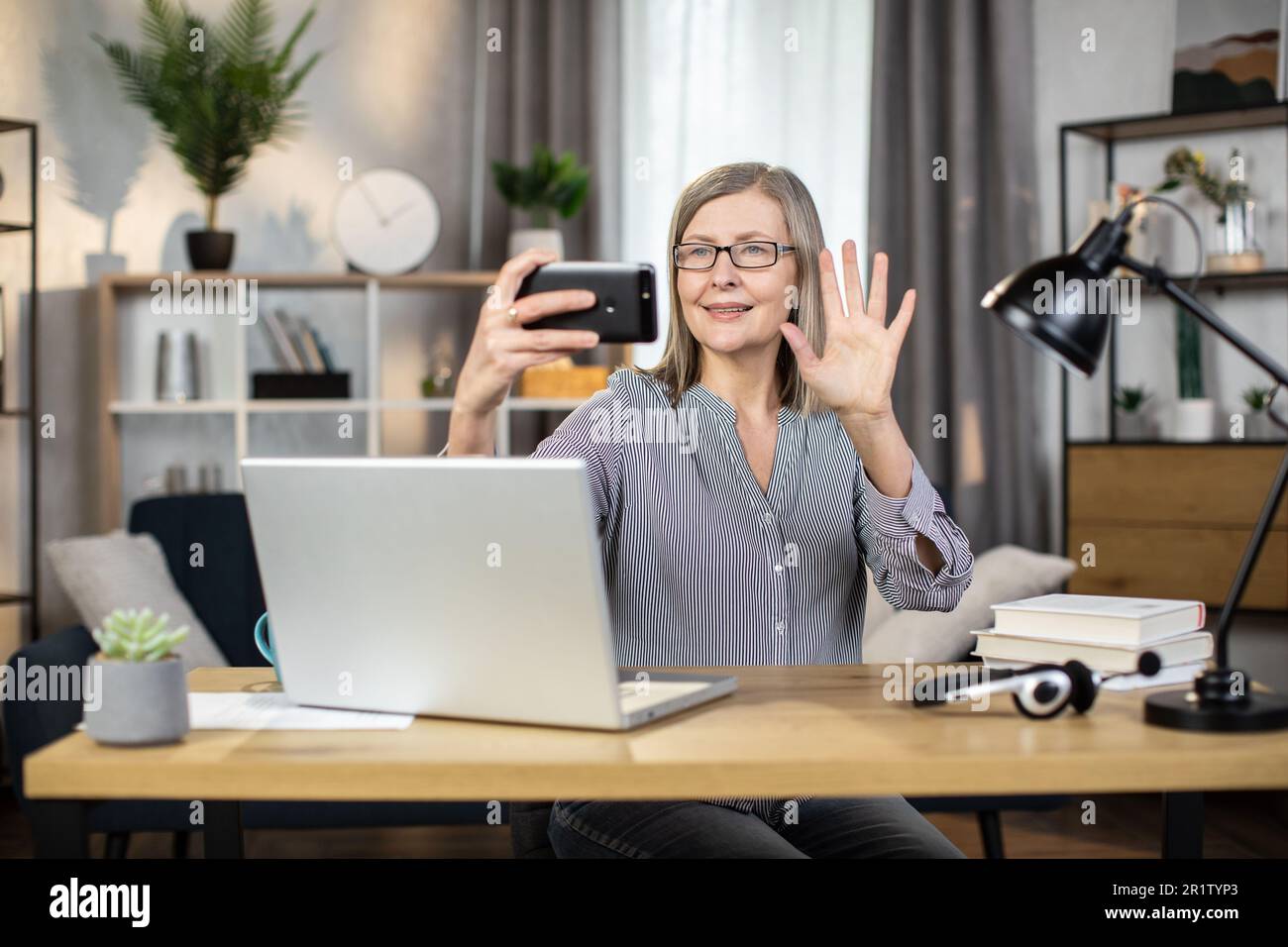Attractive caucasian lady of middle age holding mobile phone while ...