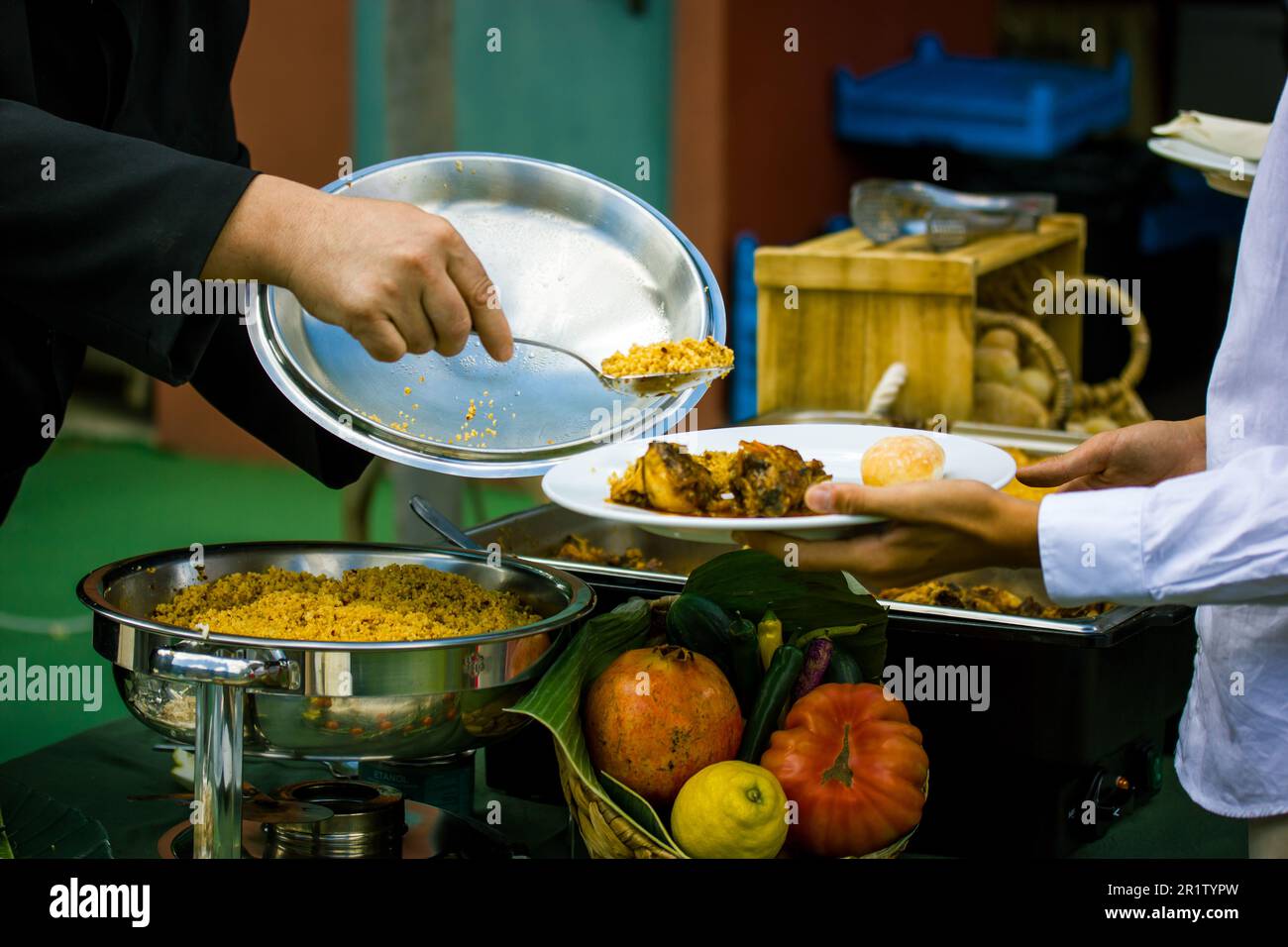 The chef, the cook puts freshly cooked food on the plate. Food tray ...