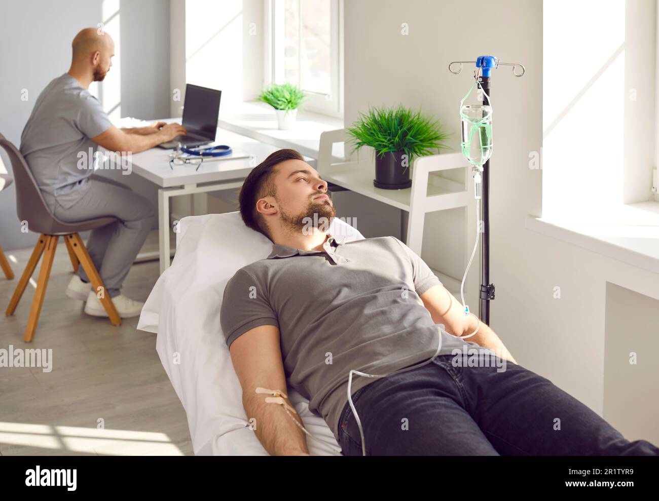 Young male patient getting vitamin or medication solution through IV ...