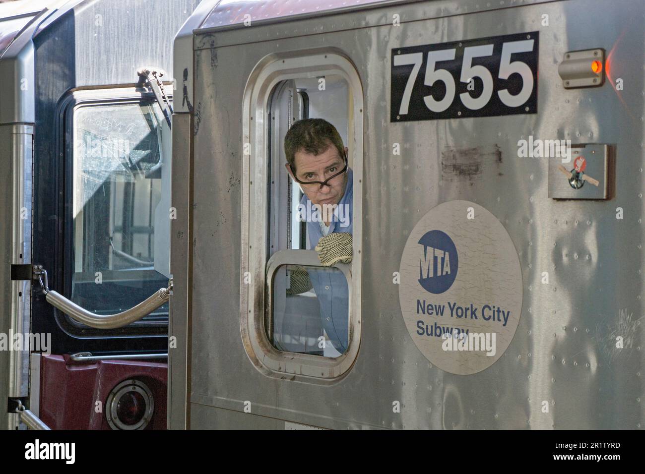 A subway conductor looks out of his window checking the doors prior to ...