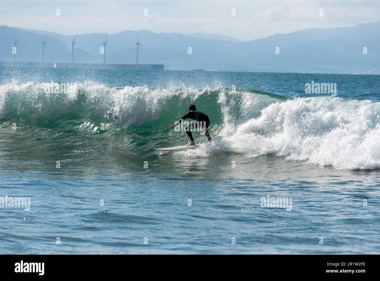 A surfer rides a wave in the ocean. Sopelana beach near Bilbao (Basque ...
