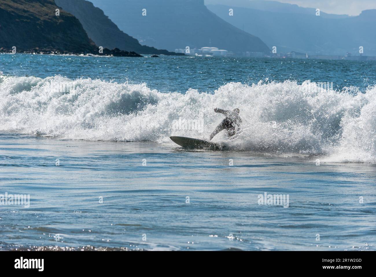 A surfer rides a wave in the ocean. Sopelana beach near Bilbao (Basque ...