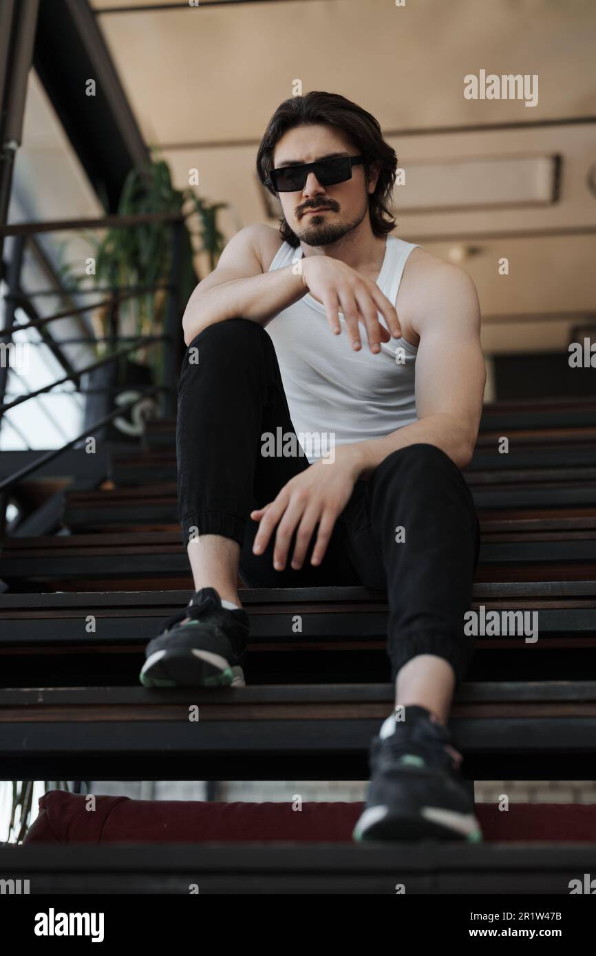 Serious man sitting on steps Stock Photo - Alamy