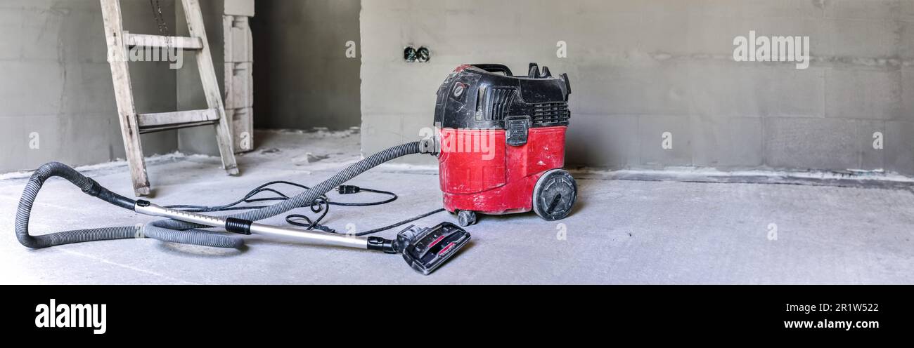 Red industrial vacuum cleaner at new house construction site, wide ...