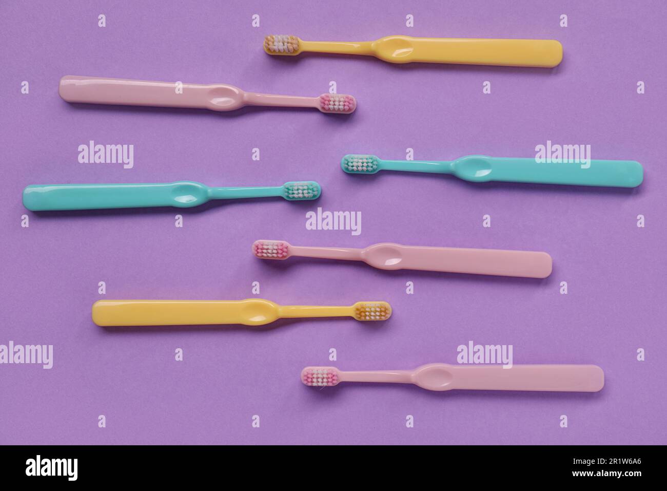 Many plastic toothbrushes on purple background Stock Photo - Alamy