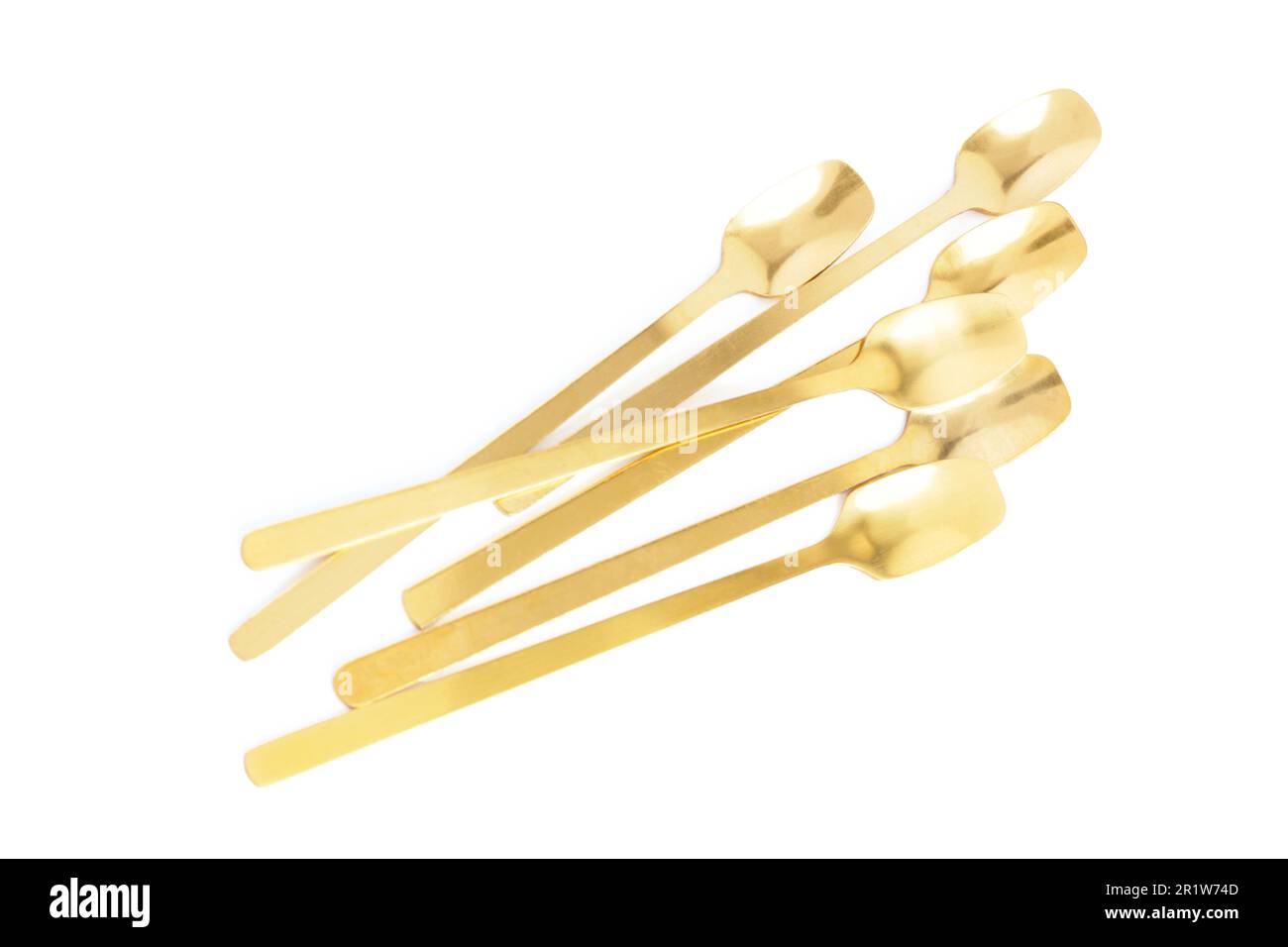 Golden spoons on white background Stock Photo - Alamy