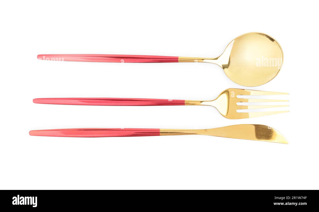 Golden cutlery with red handles on white background Stock Photo - Alamy