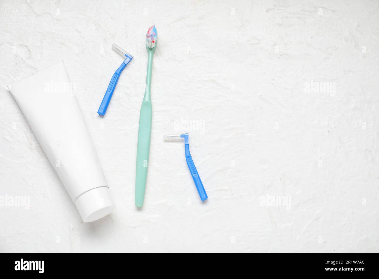 Toothbrush, toothpicks and paste on textured white background Stock ...
