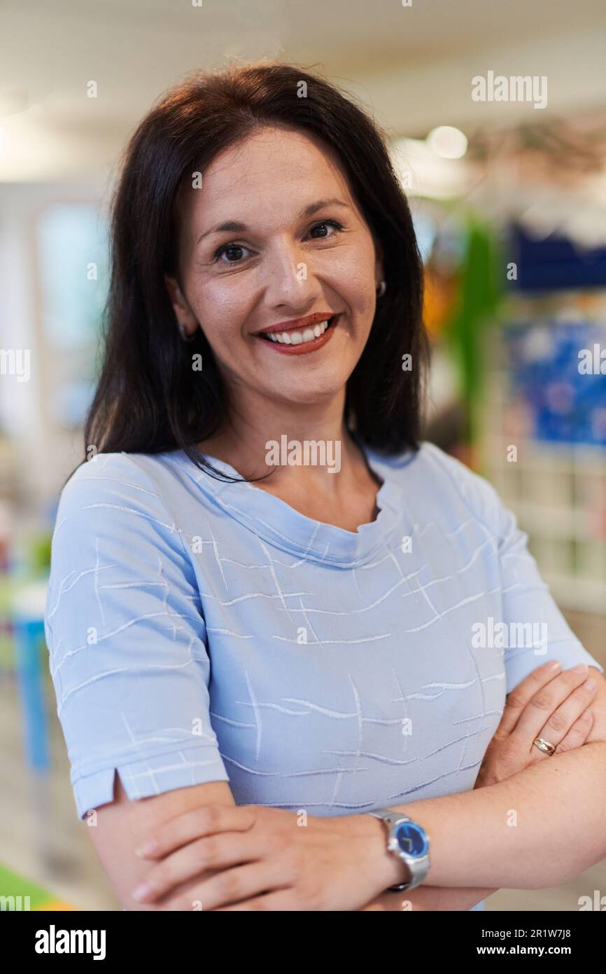 Portrait of a teacher in a preschool institution, in the background of ...