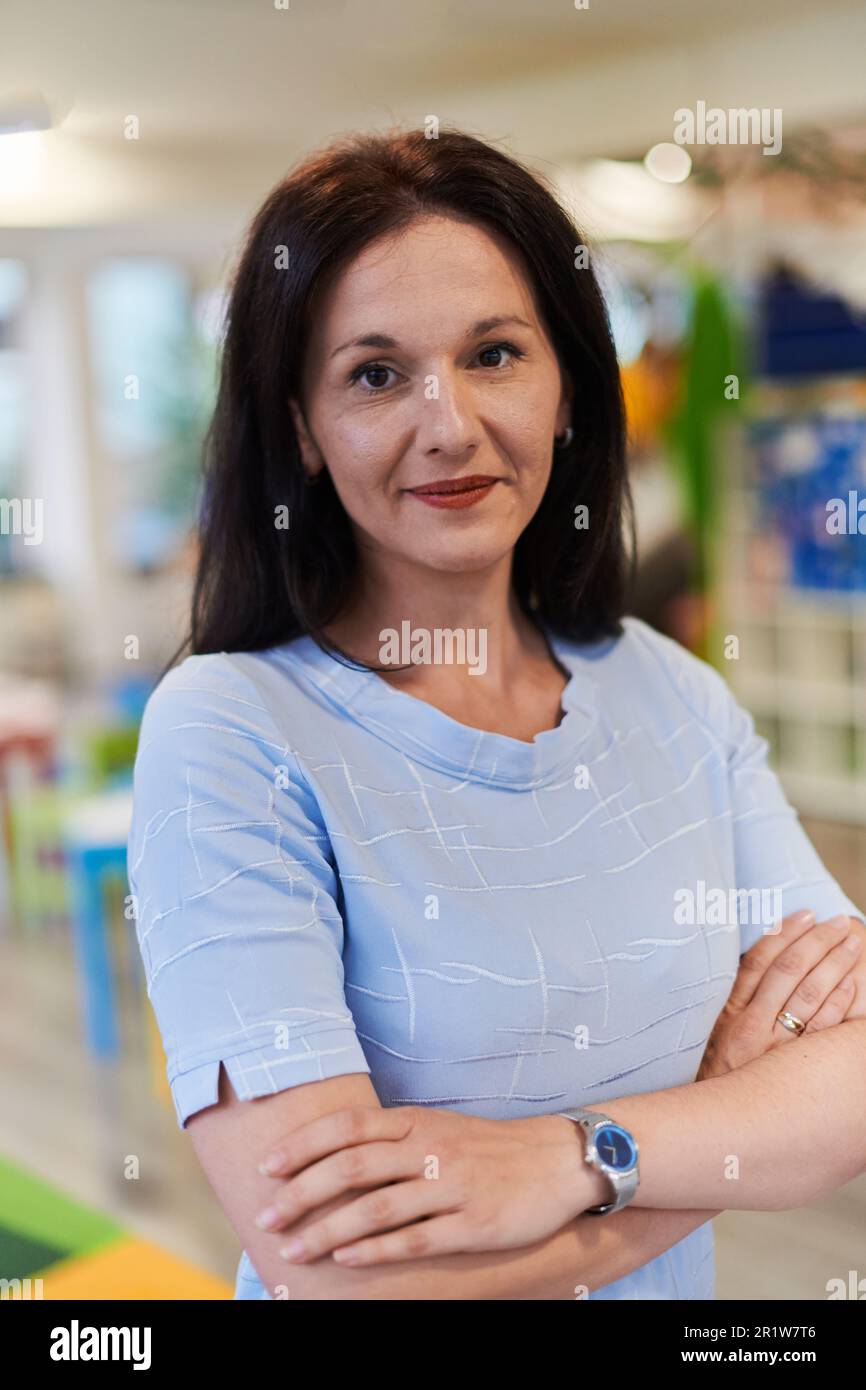 Portrait of a teacher in a preschool institution, in the background of ...
