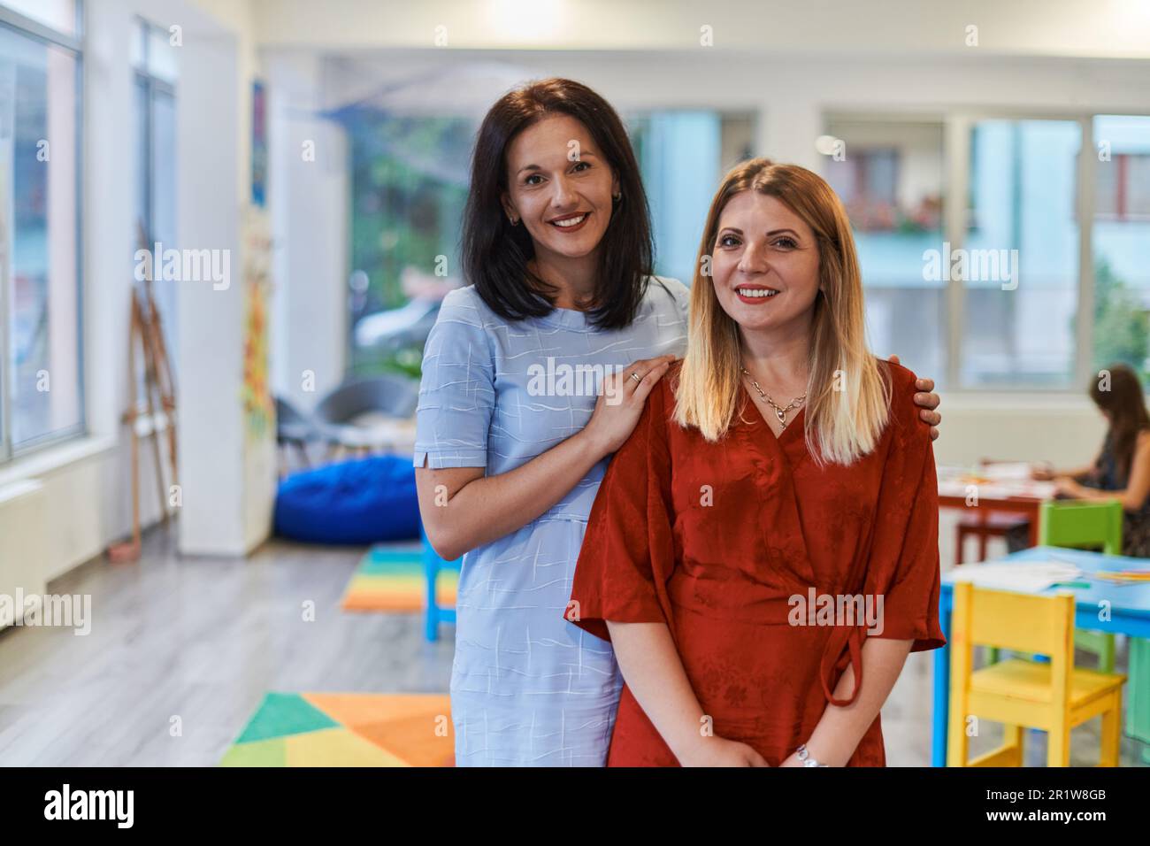 Portrait of a two teacher in a preschool institution, in the background ...