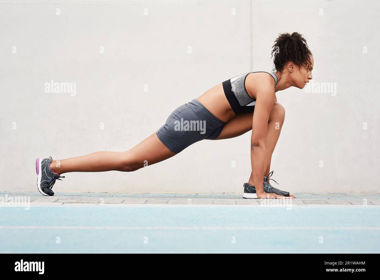 Ready, set, go. Full length shot of an attractive young female athlete standing in the set ...