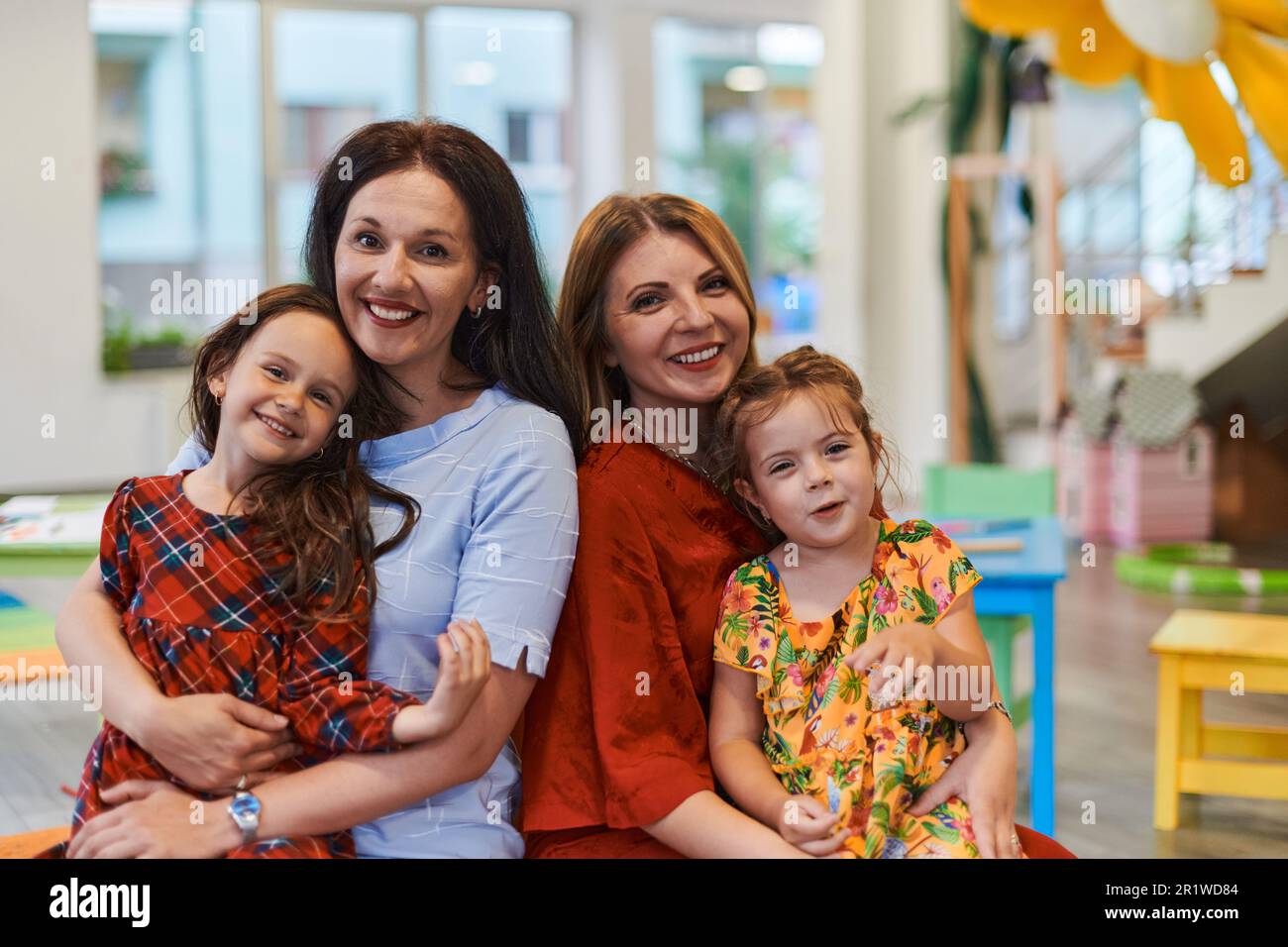 A child hugging a teacher in a modern kindergarten Stock Photo - Alamy