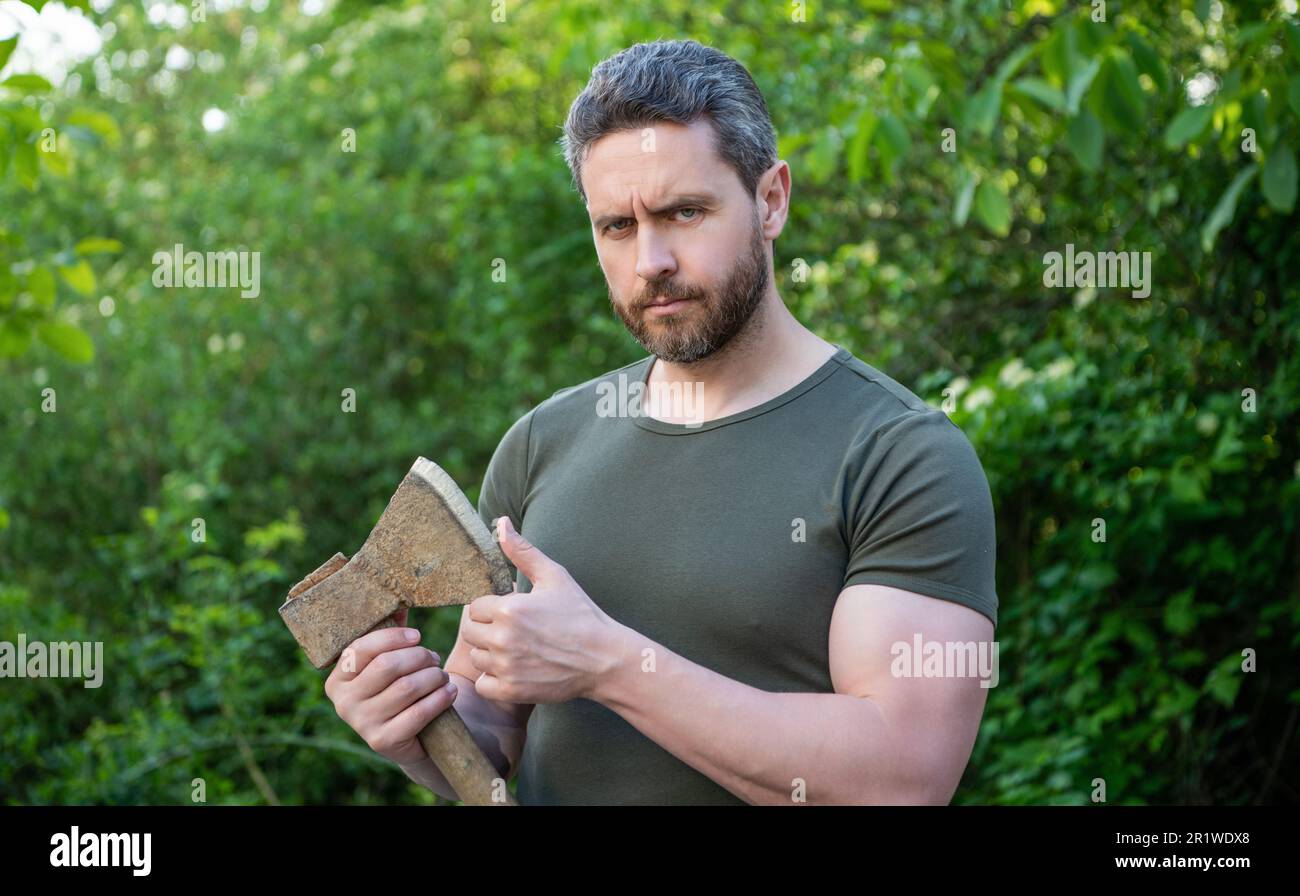 image of man hold ax. man with ax. man holding ax wearing shirt. man ...