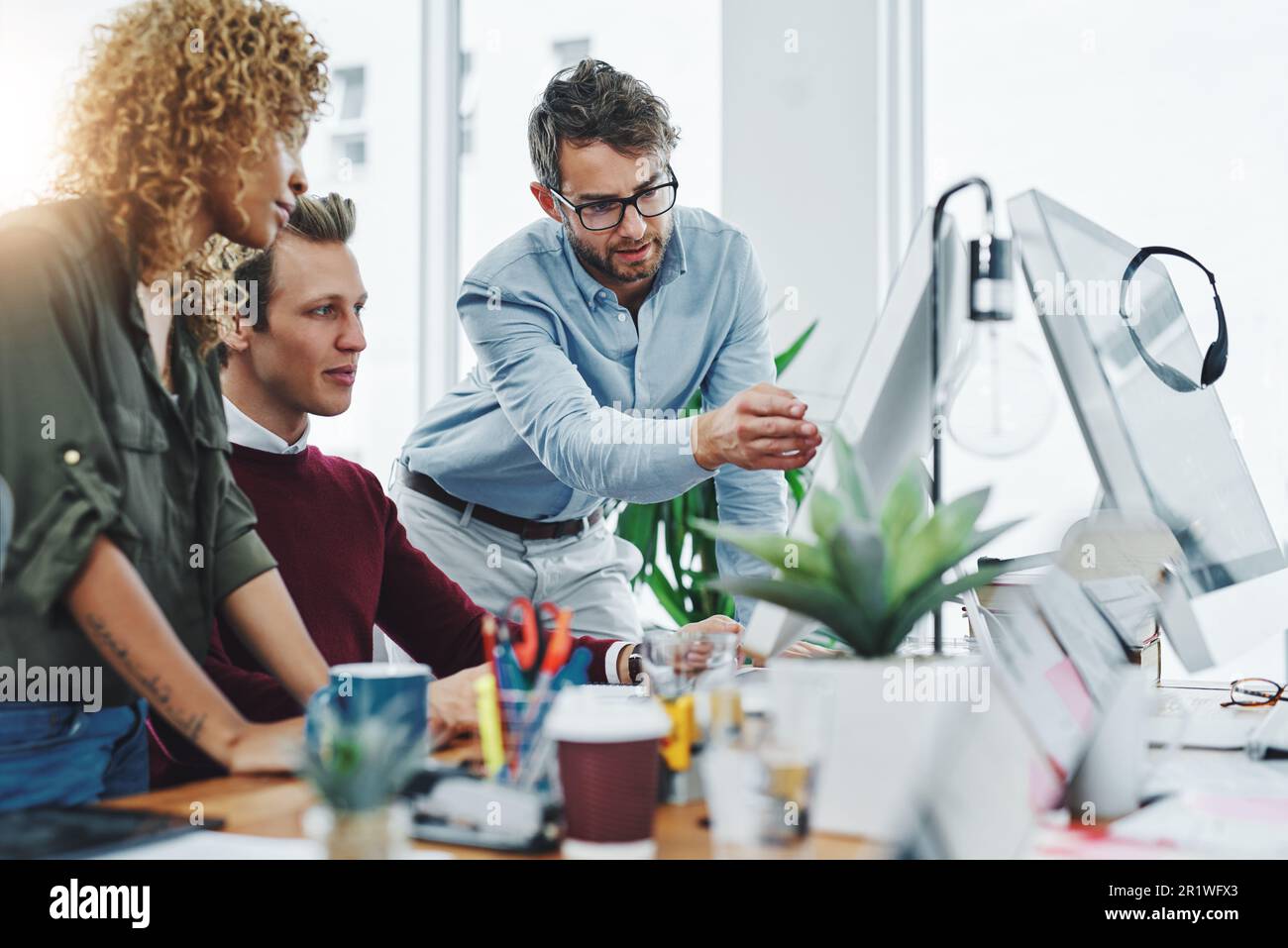 Teamwork is always the answer. a group of colleagues using a computer ...