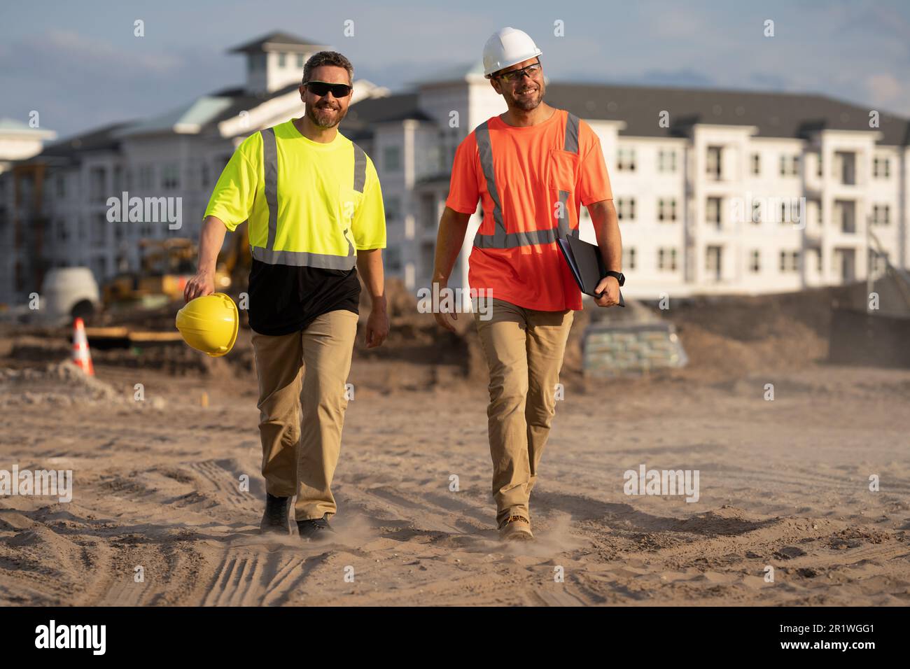positive engineer men walking at construction site. engineer men at construction site Stock ...