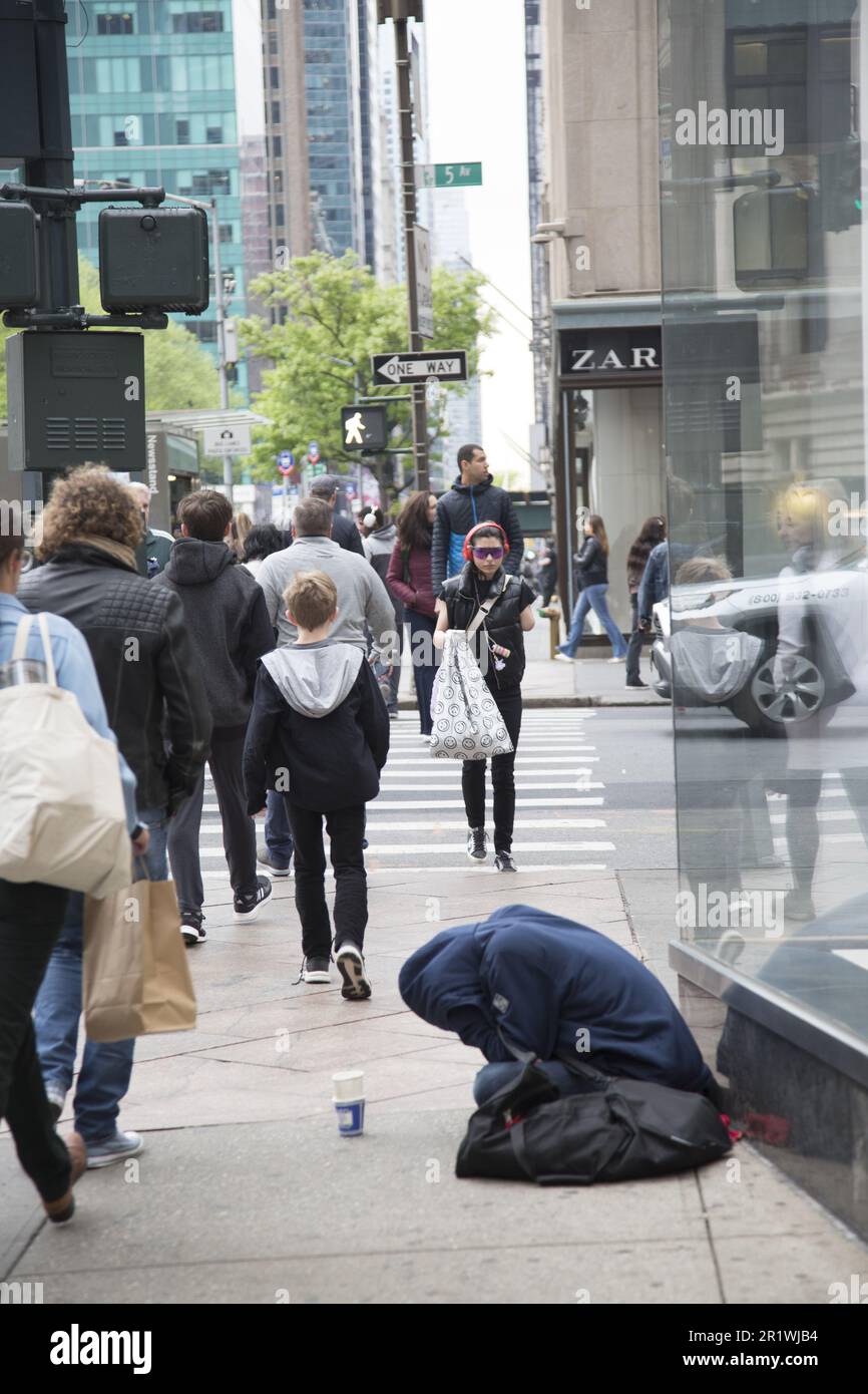 Homeless man begs along 5th Avenue sitting on the sidewalk in midtown ...