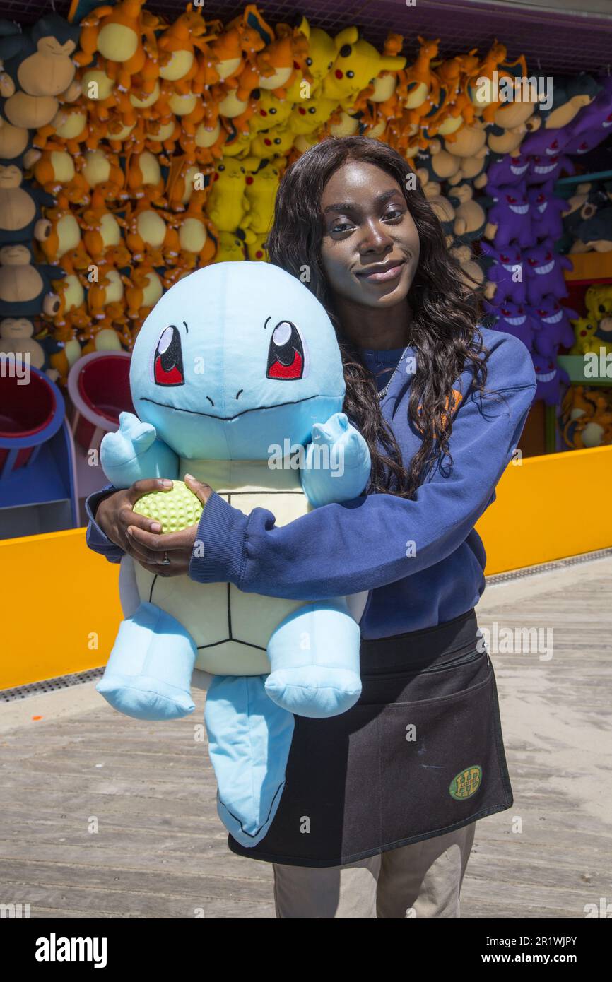 Portrait of a teenage worker in front of a game arcade on the boardwalk ...