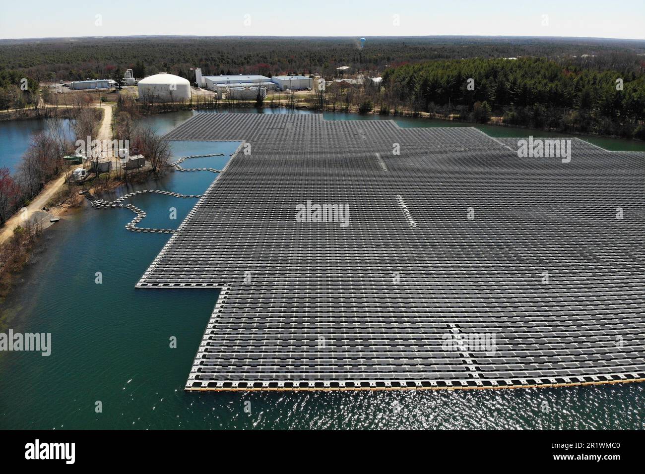 An array of solar panels float on top of a water storage pond in ...