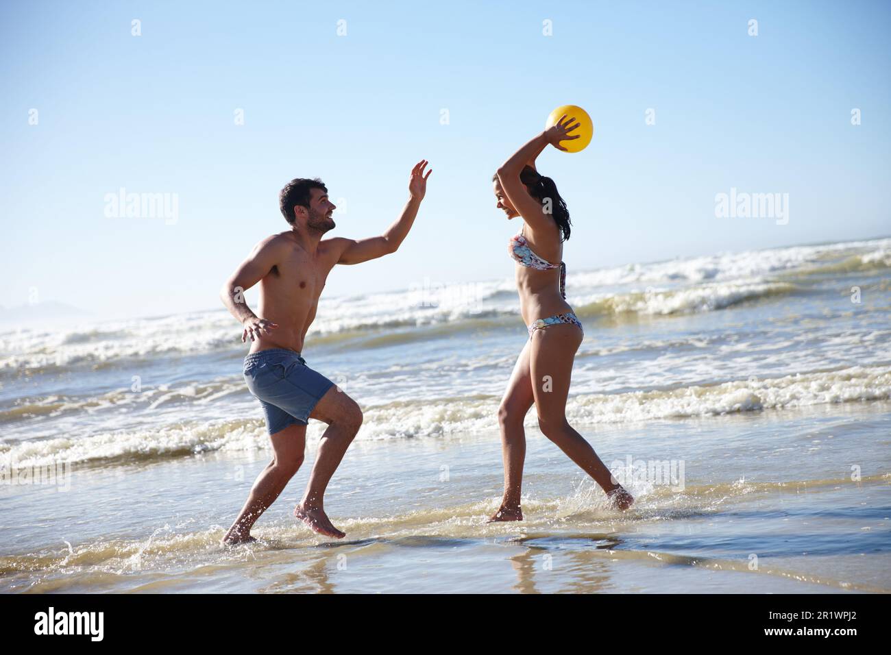 Theyre well matched. a happy couple playing in the shallow water together on the beach Stock ...