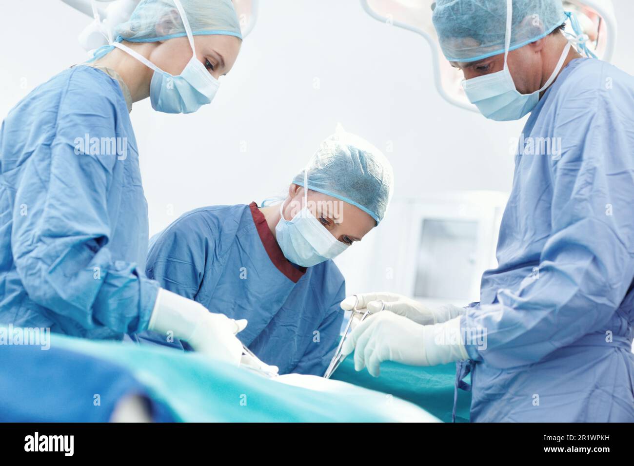 A stitch in time. Surgeons using medical tools and forceps to operate ...