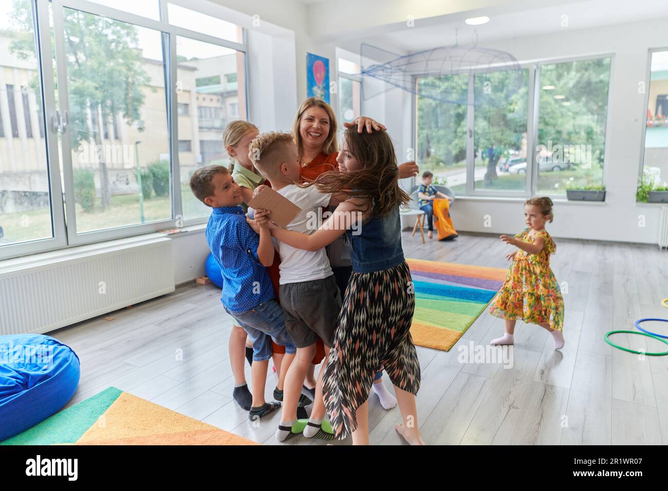 A child hugging a teacher in a modern kindergarten Stock Photo - Alamy