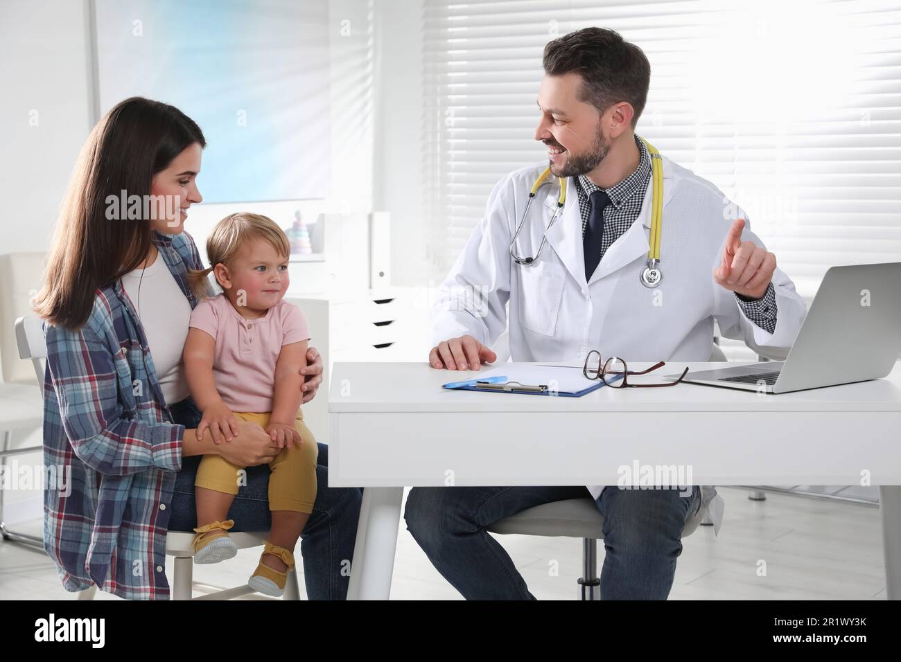 Mother and her cute baby having appointment with pediatrician in clinic ...