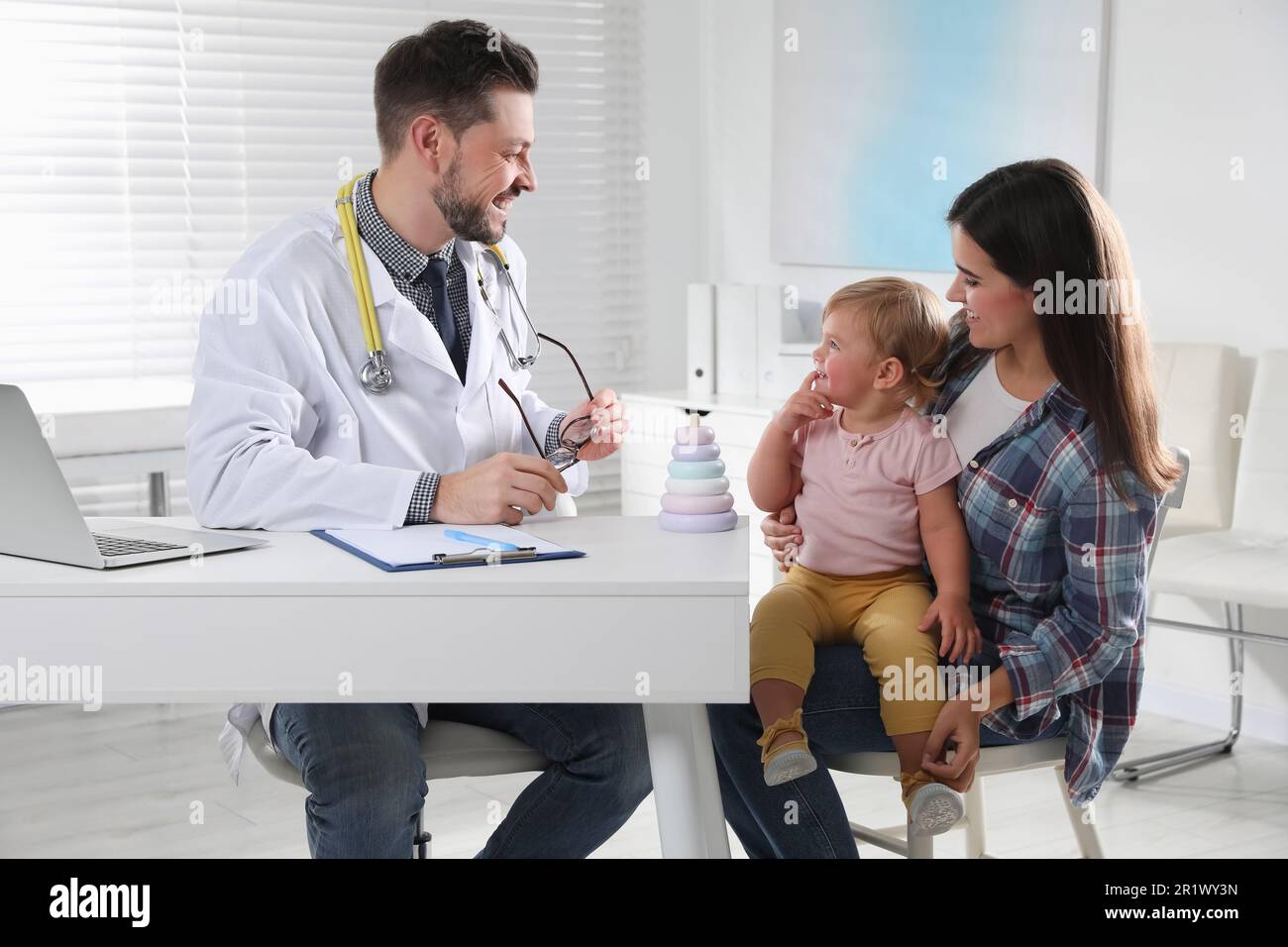 Mother and her cute baby having appointment with pediatrician in clinic ...