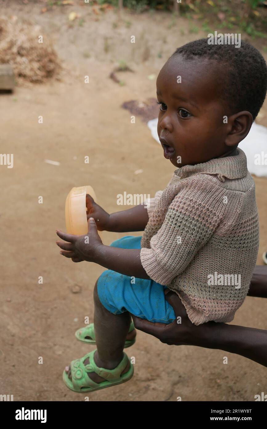Jinka, Ethiopia â€“ 11.16.2022: man picks up an adorable baby boy in an ...