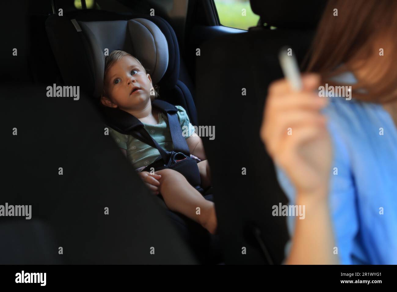 Mother with cigarette and child in car, closeup. Don't smoke near kids ...