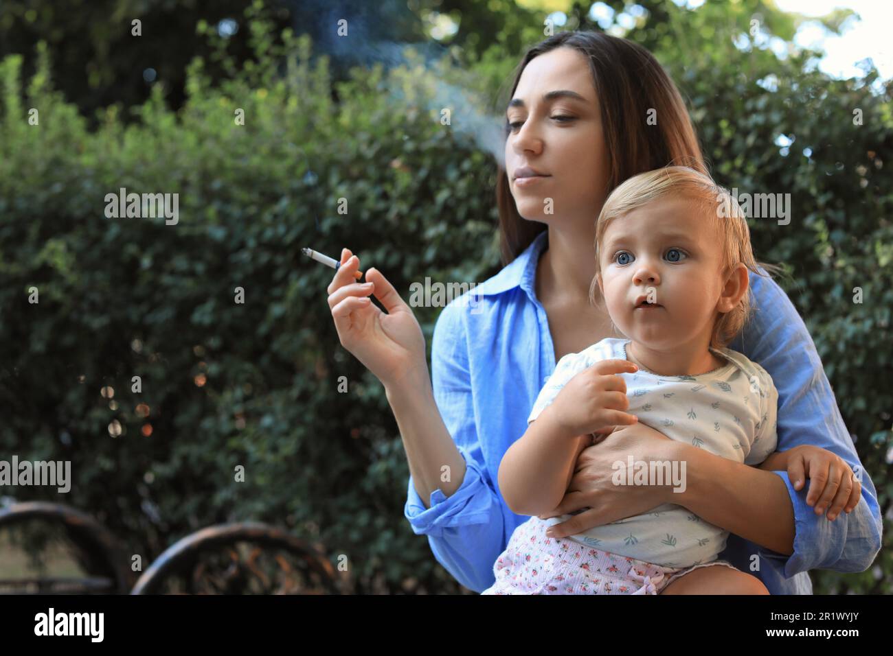 Mother with cigarette and child outdoors. Don't smoke near kids Stock Photo - Alamy
